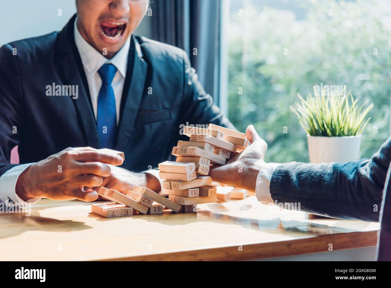 Business man strategy risk pulling block wood tower and have one ...