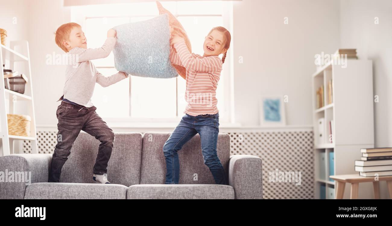 Cute children fighting by pillows on the sofa. Concept of friendship ...