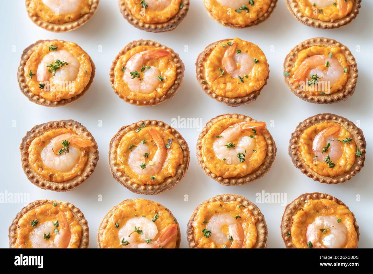 Bunch of shrimp tartlets with cheesy sauce Stock Photo - Alamy