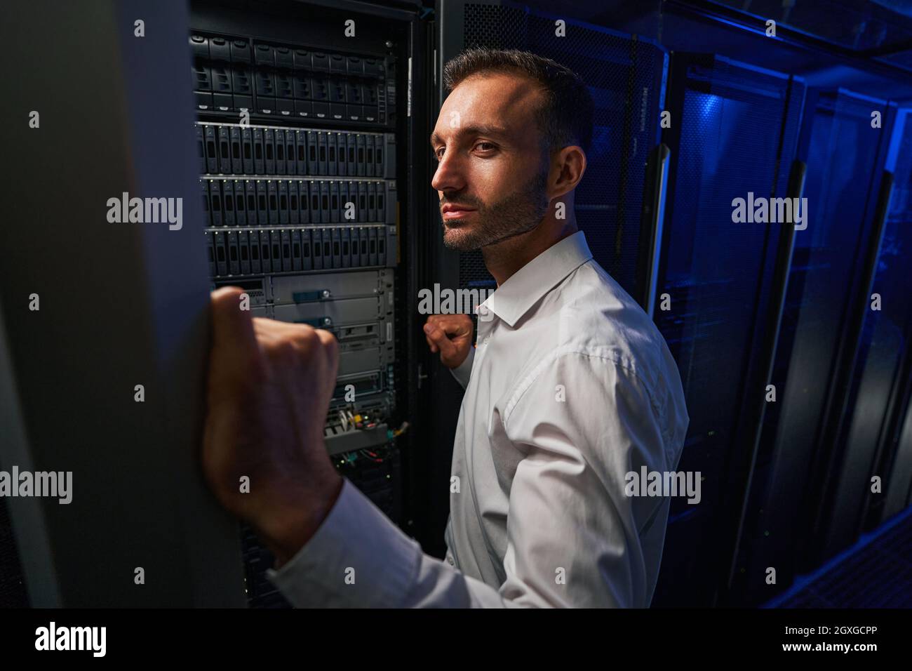 Bearded busy man technician finding and troubleshooting computer server ...