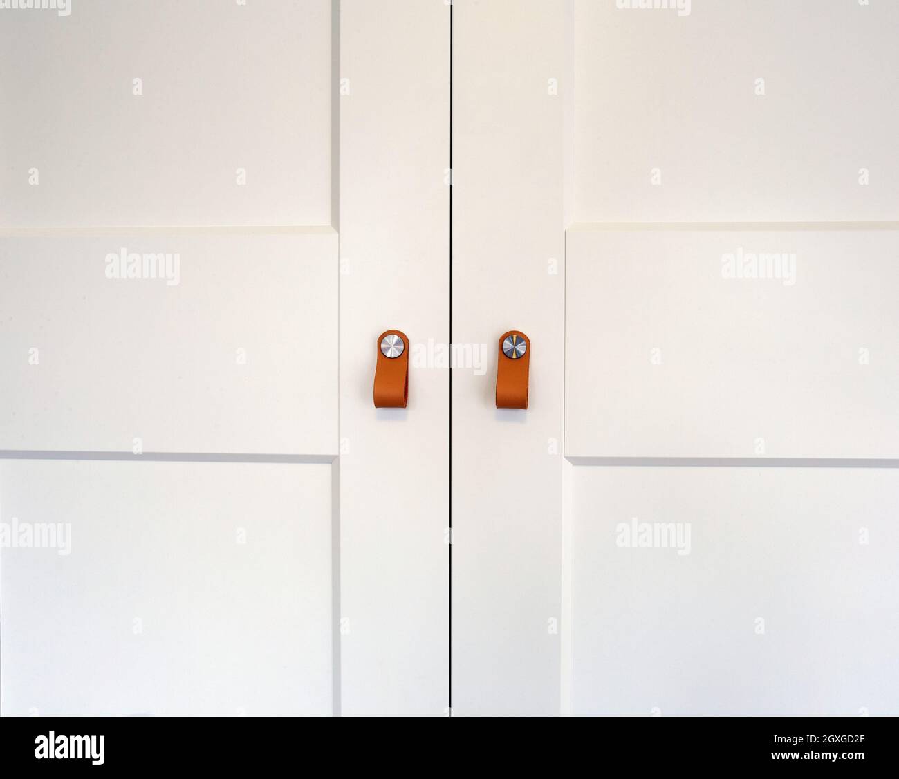White wooden closet doors with retro brown leather handles wood closeup ...