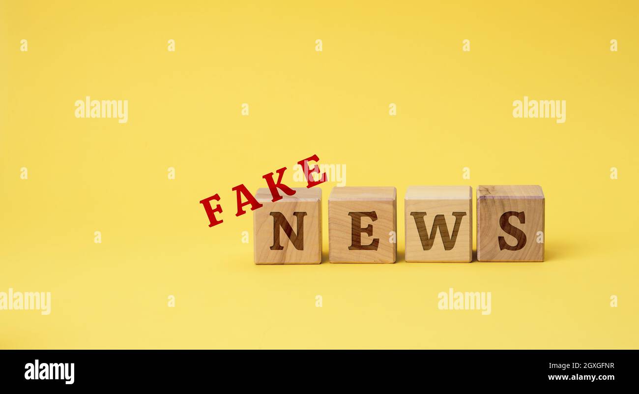 wooden cubes with the inscription false news on a yellow background ...