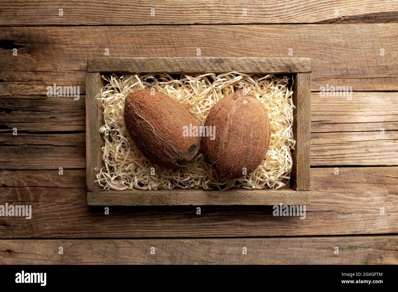 Fresh tropical coconut fruit in a wooden delivery box on a wooden ...
