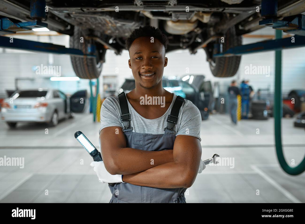 Male worker checks car suspension, auto service. Vehicle repairing ...