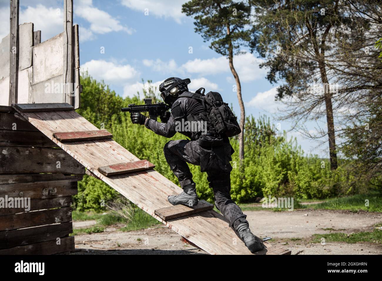Spec ops police officer SWAT in black uniform in action Stock Photo - Alamy