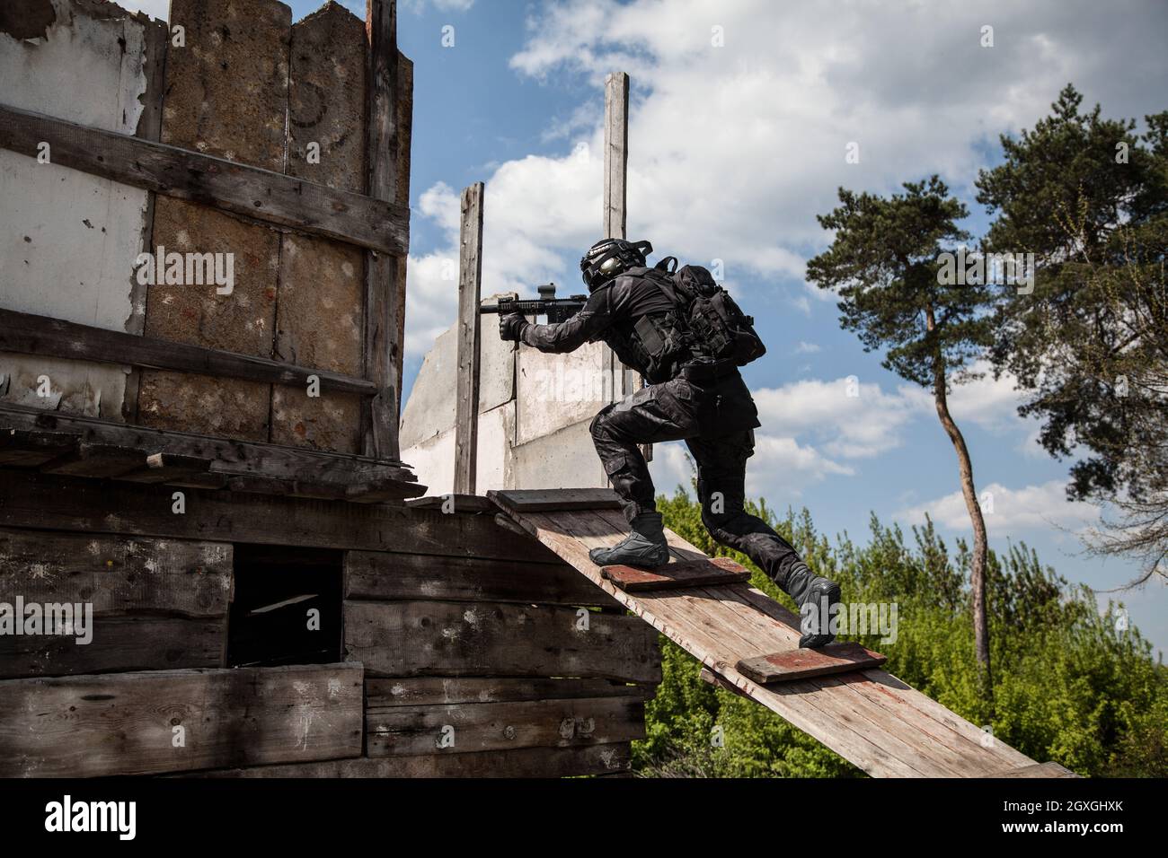 Spec ops police officer SWAT in black uniform in action Stock Photo - Alamy