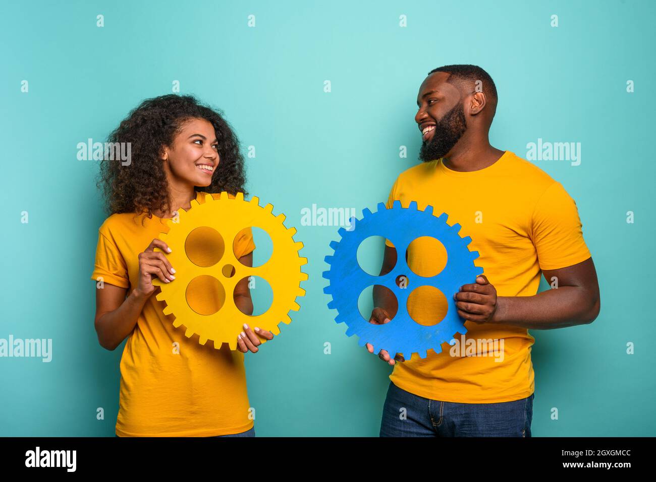 Couple with gears in hand over light blue background. Concept of ...
