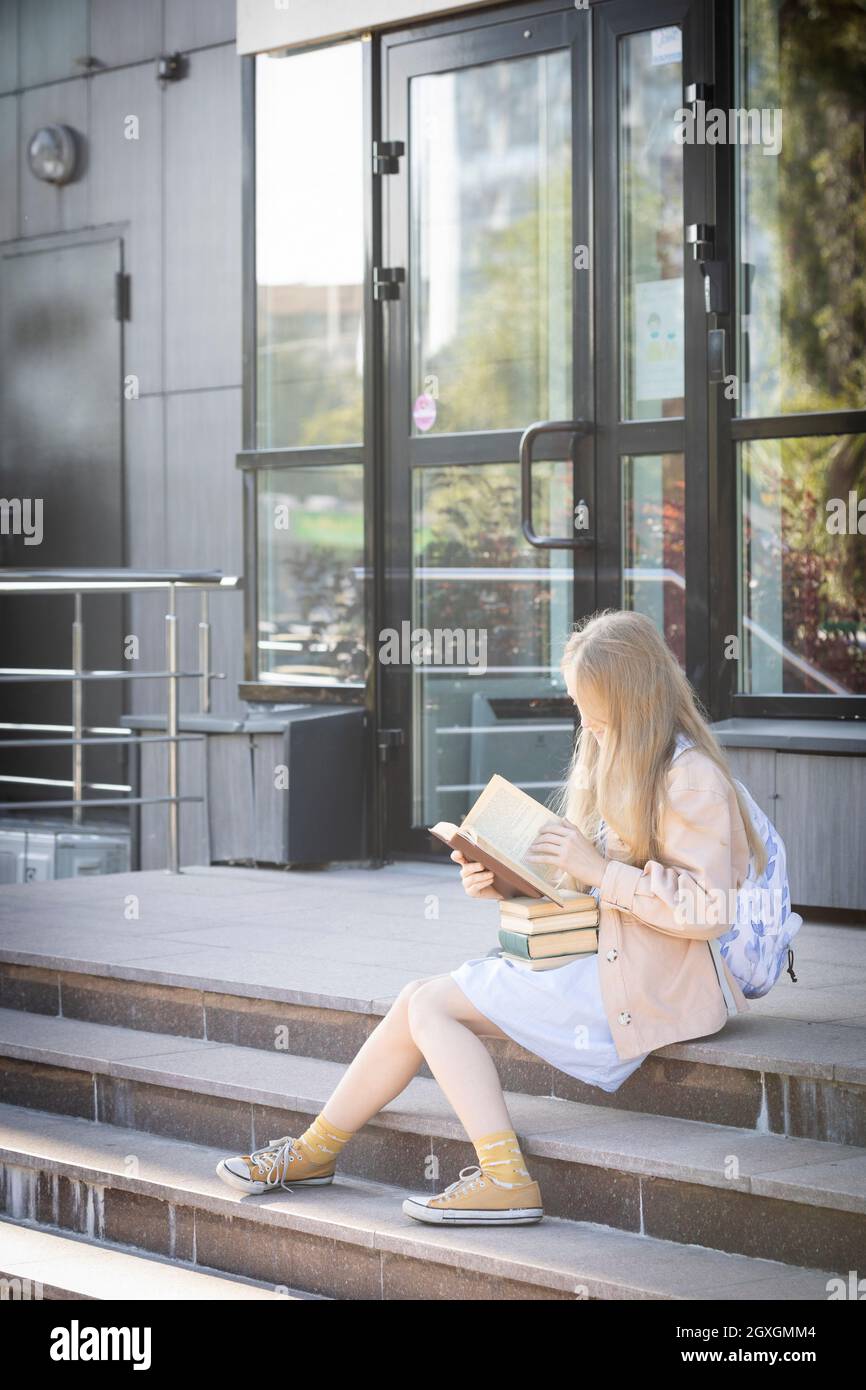 girl with books sitting on the steps Stock Photo - Alamy