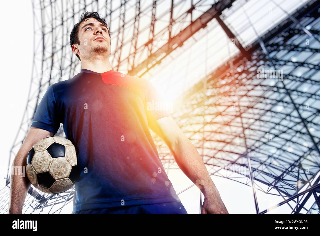 Soccer player ready to play with soccerball at the illuminated stadium ...