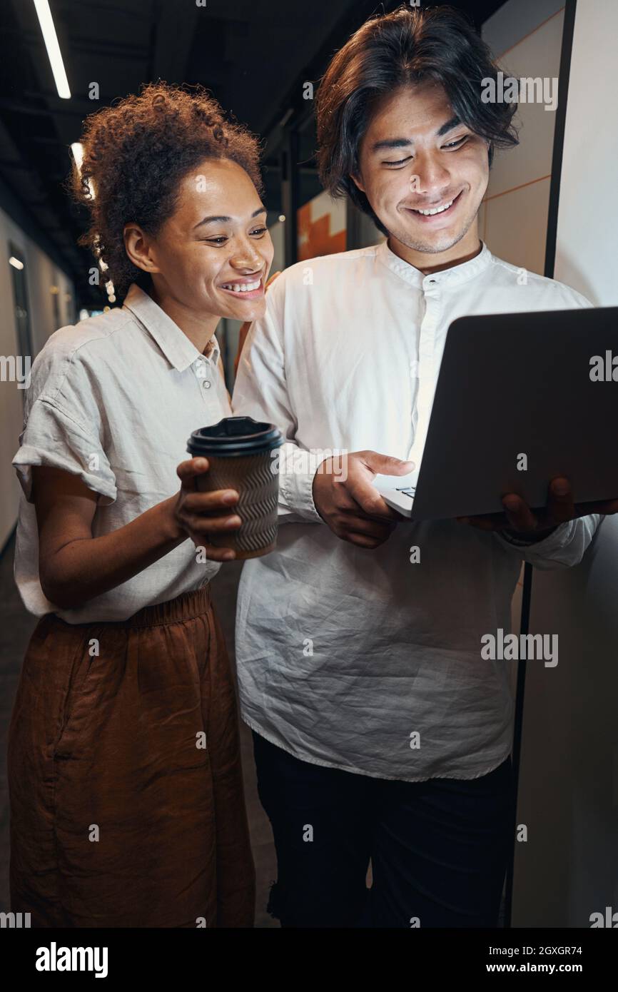 Employees looking at screen of laptop with happiness Stock Photo - Alamy