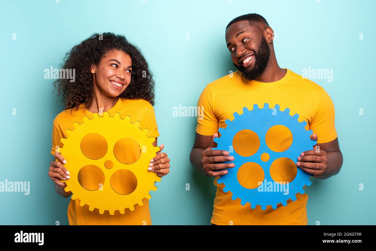 Couple with gears over light blue background. Concept of integration ...