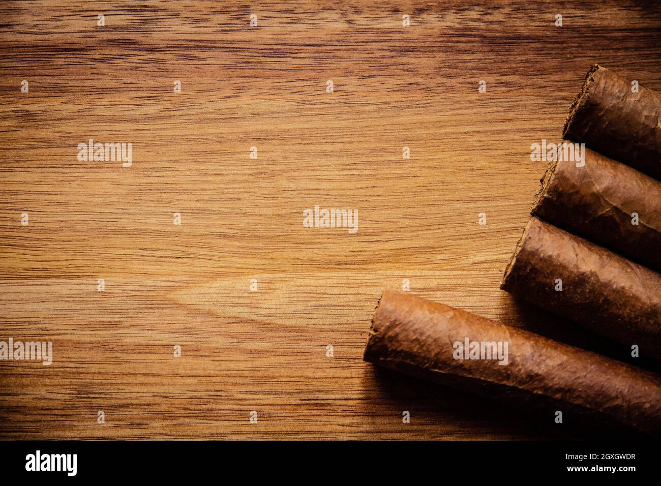 Group of brown cuban cigars on old wooden background Stock Photo - Alamy