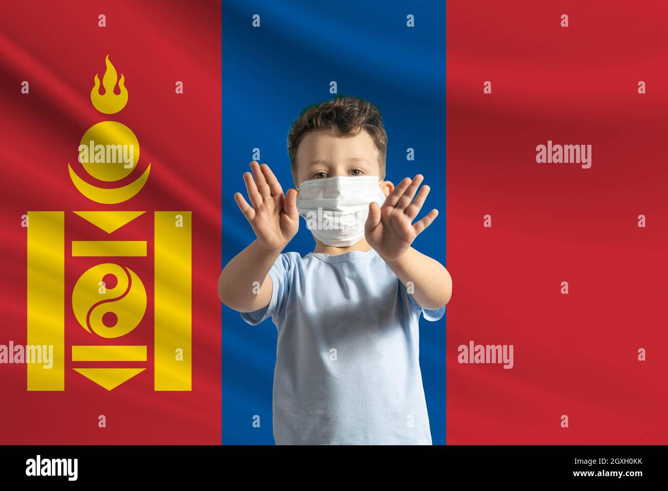 Little white boy in a protective mask on the background of the flag of ...
