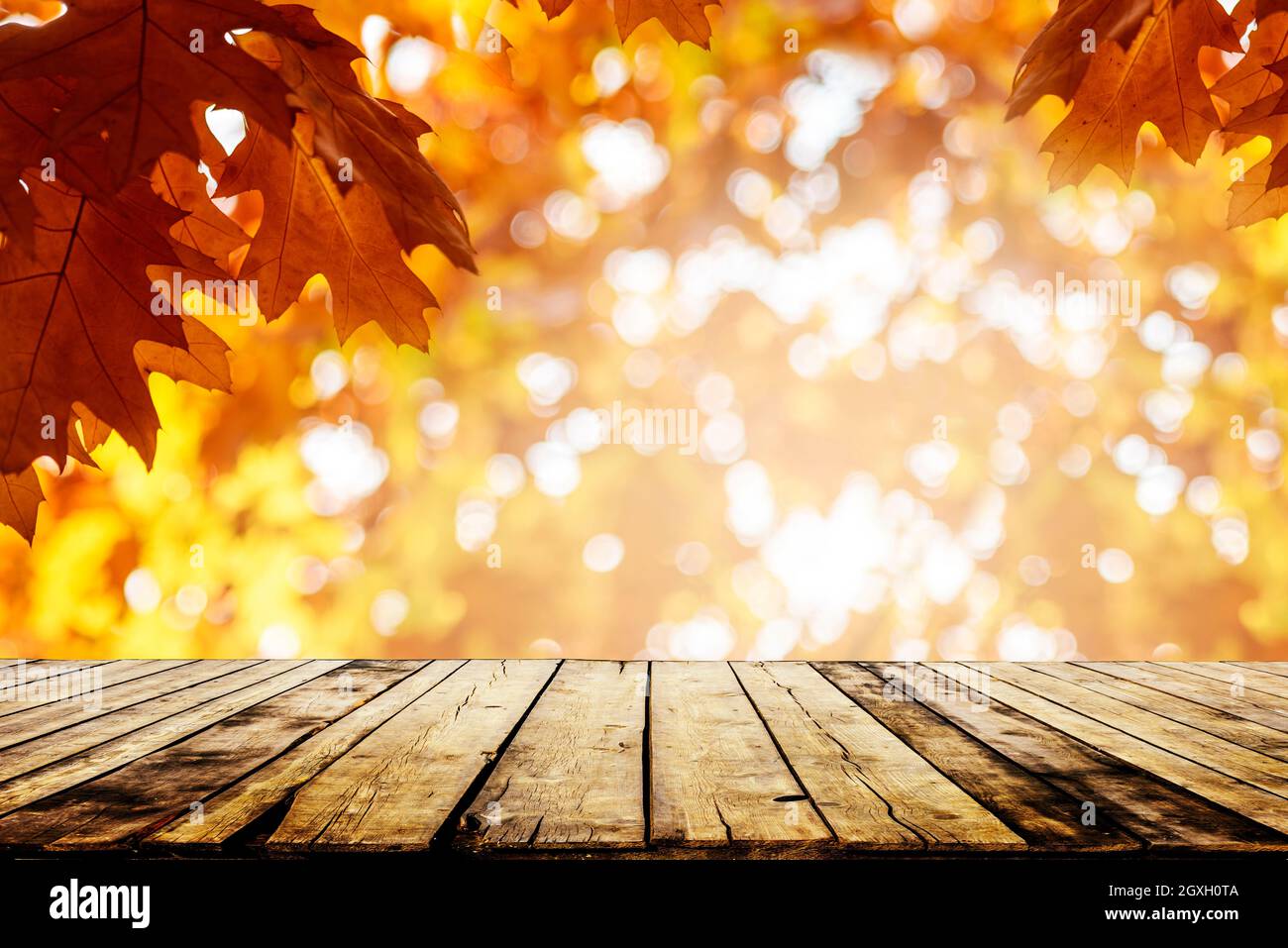 Old rustic wooden table with autumn leaves blur background. Seasonal ...