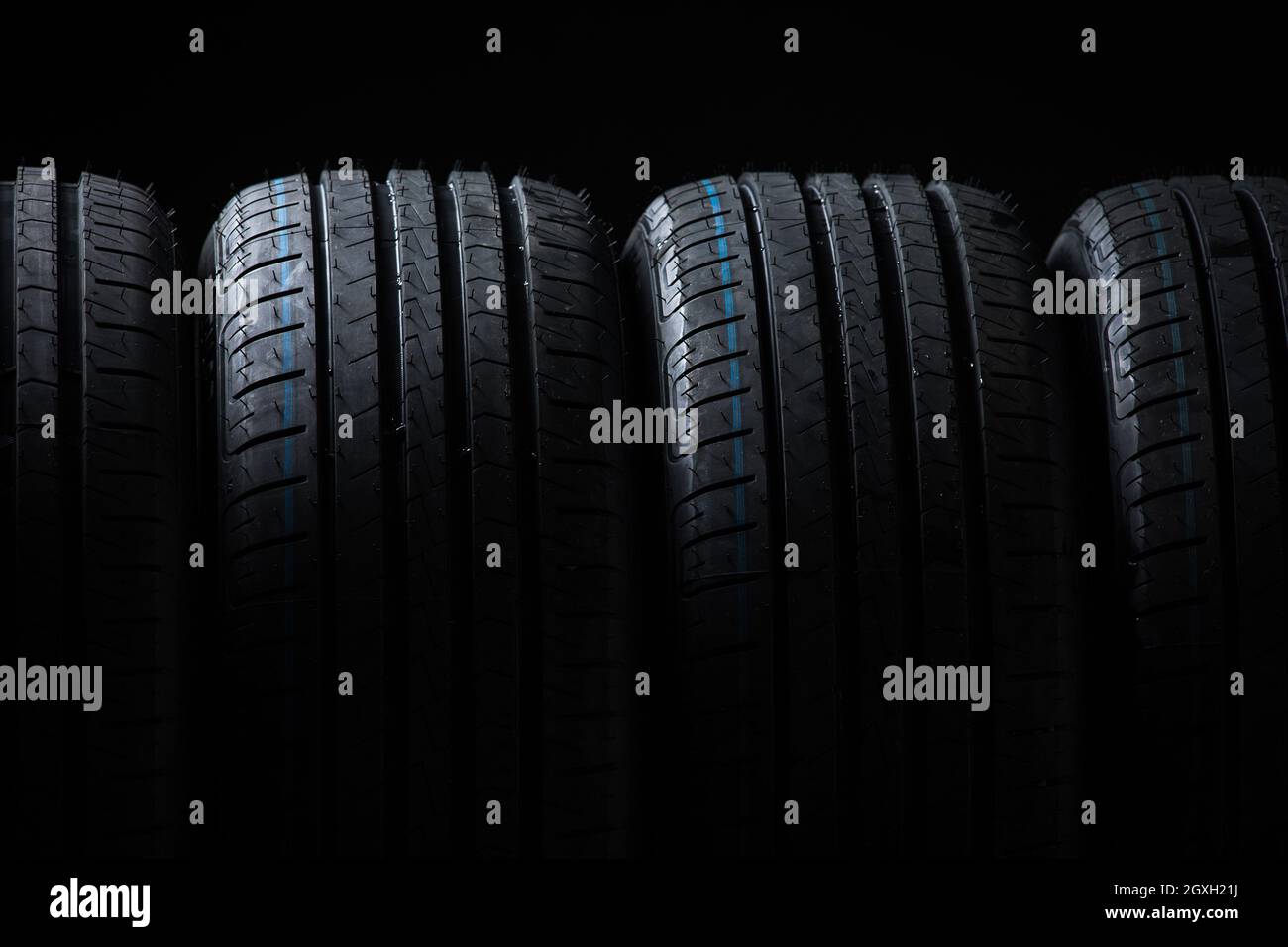 Stack of brand new high performance car tires on clean high-key white ...