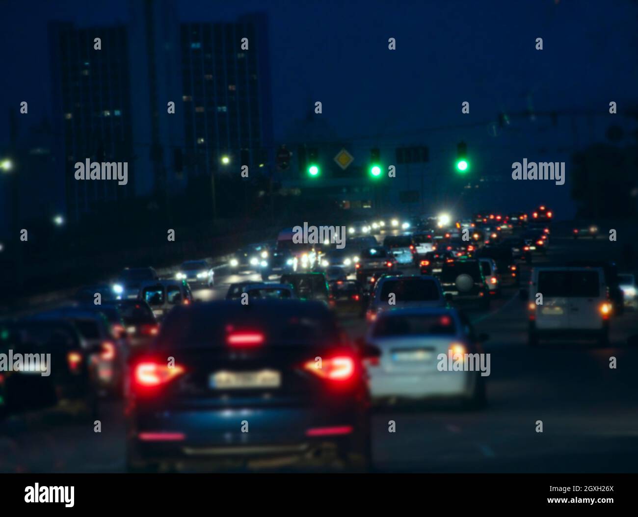 stream of cars in evening traffic jam. Automobiles with headlights and ...