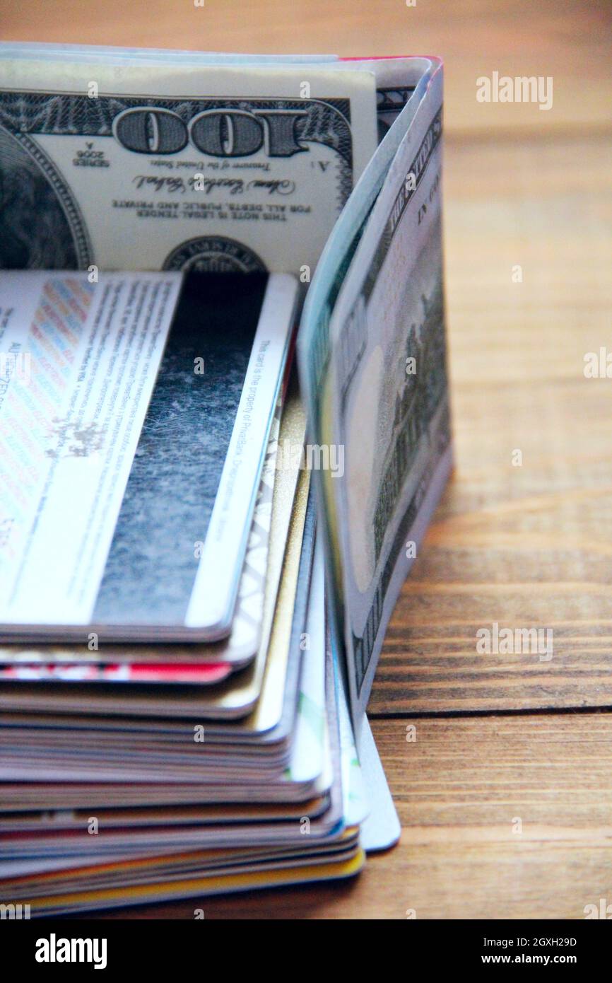 Hundred dollar notes and credit cards. Pile of credit cards fenced in ...