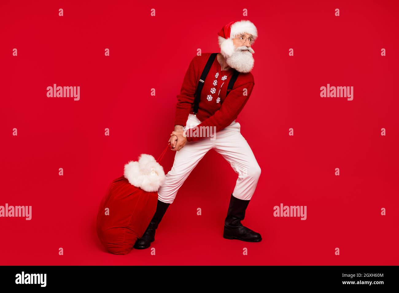 Full length body size view of Santa carrying heavy giftboxes midnight ...