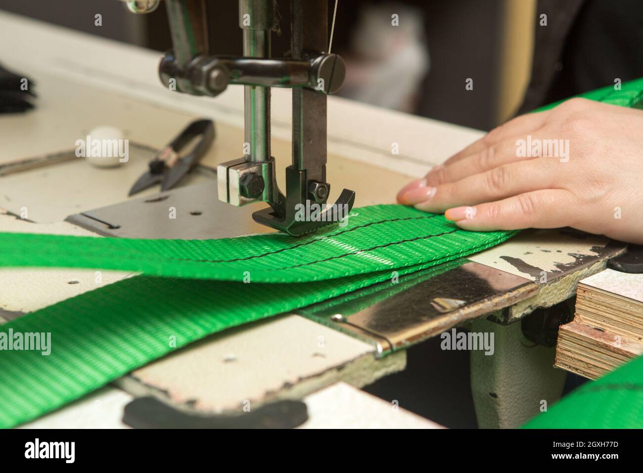 Industrial sewing machine sews a webbing sling. Manufacture of textile ...