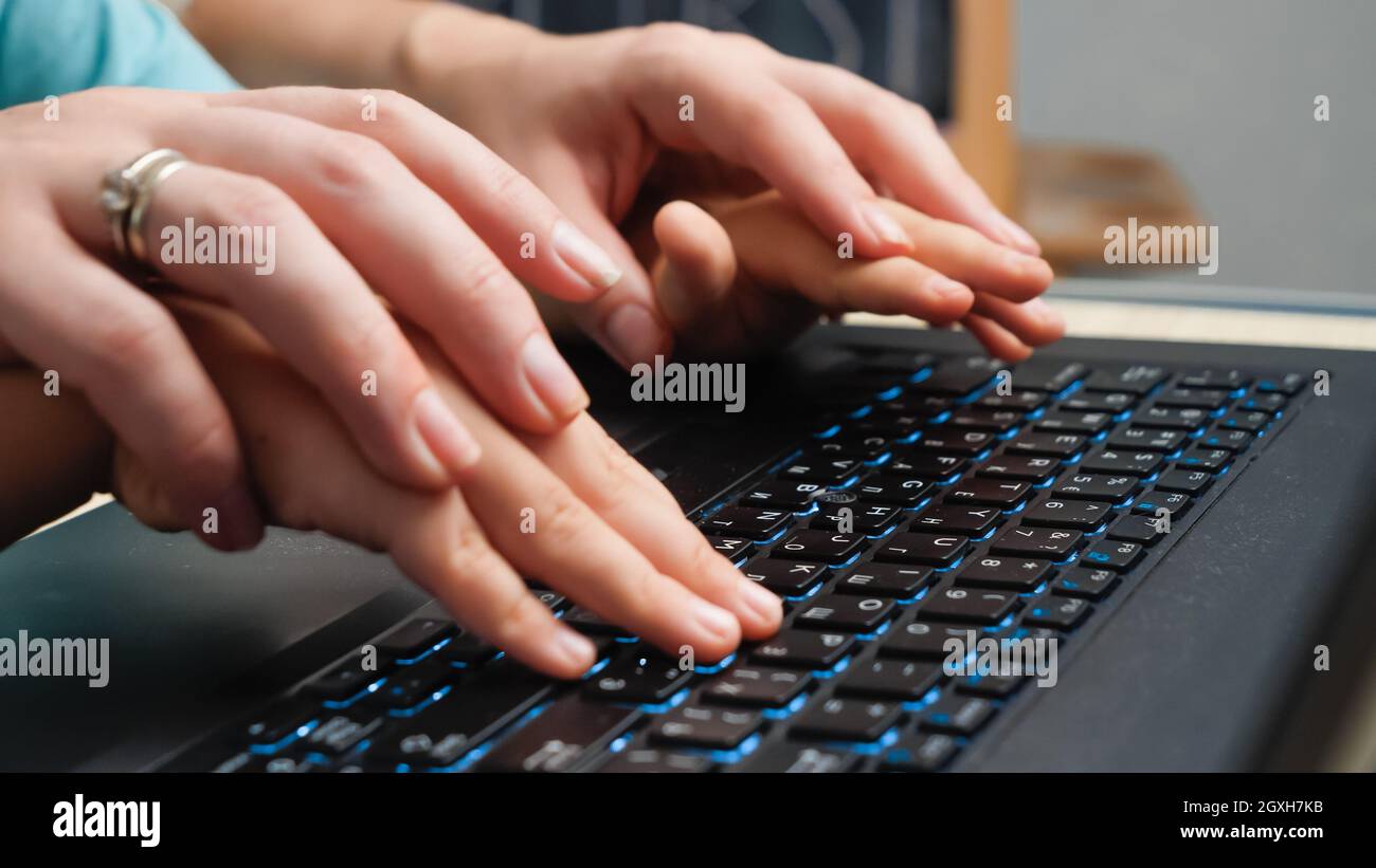 Closeup of mother teaching little son typing and using laptop keyboard ...