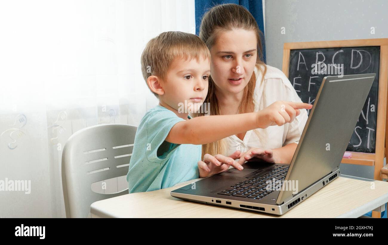 Little boy with young mother studying on laptop. Children using ...