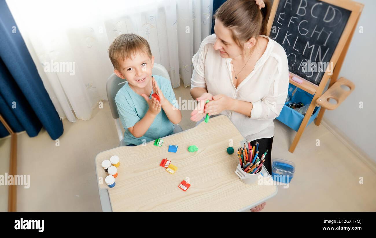 Top view shot of boy with mother shaping and sculpting colorful ...