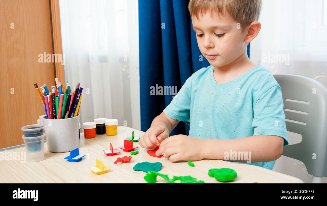 Smiling toddler boy shaping and sculpting forms and shapes with ...