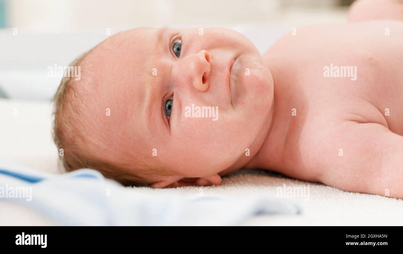 Portrait of unhappy crying newborn baby lying on changing table Stock ...