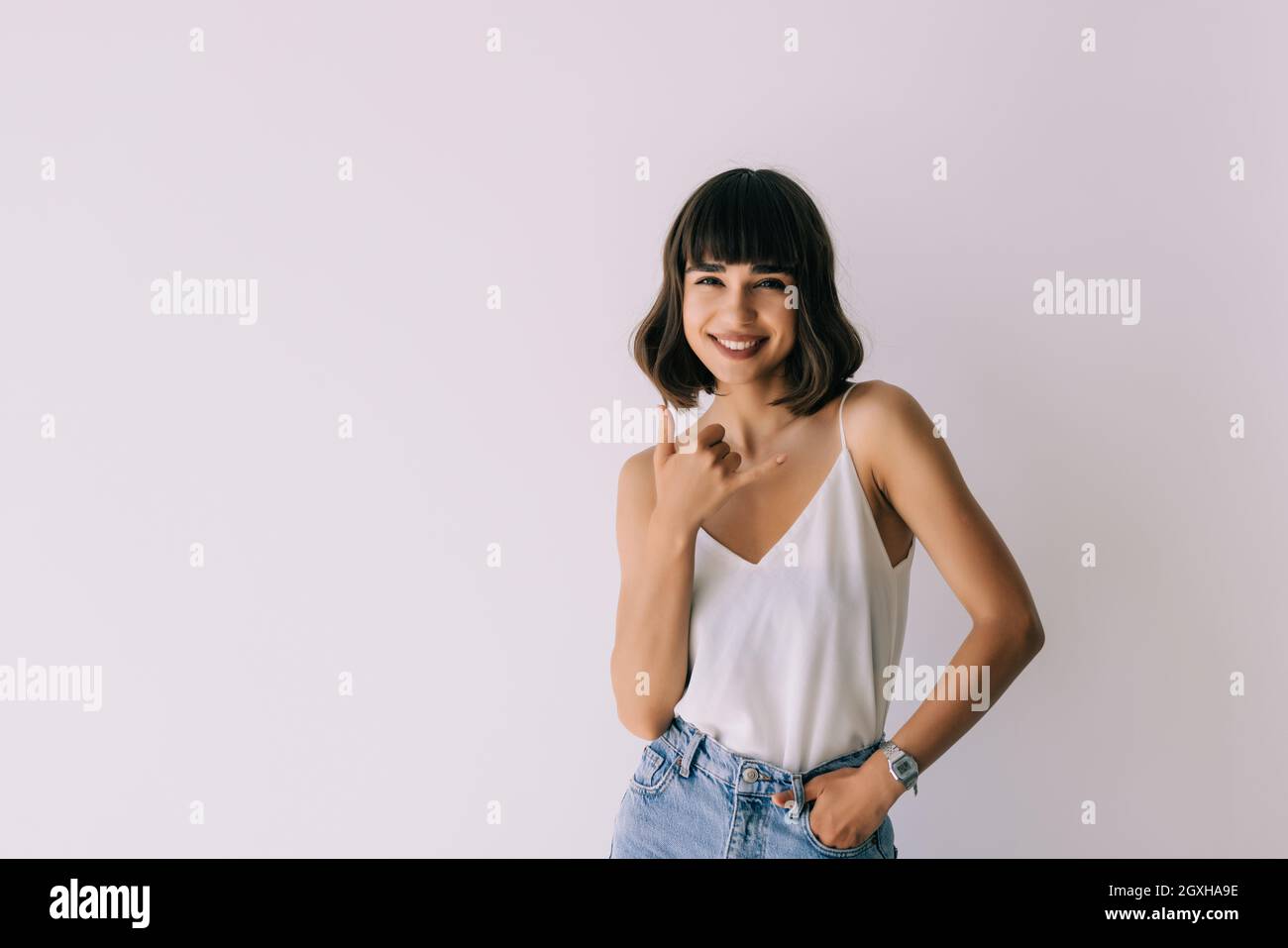 Portrait of young pretty woman making the call me sign gesture isolated ...