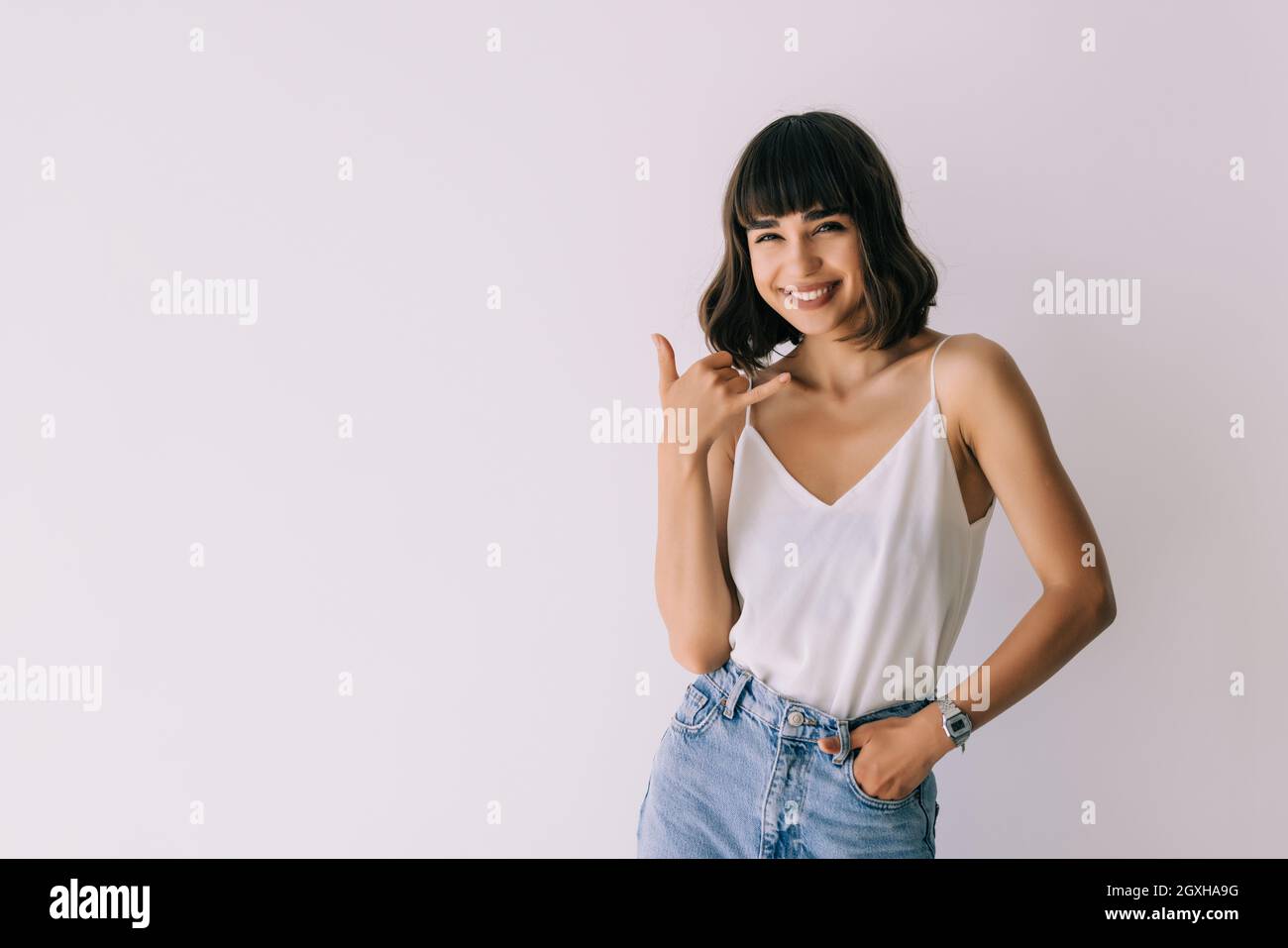 Portrait of young pretty woman making the call me sign gesture isolated ...