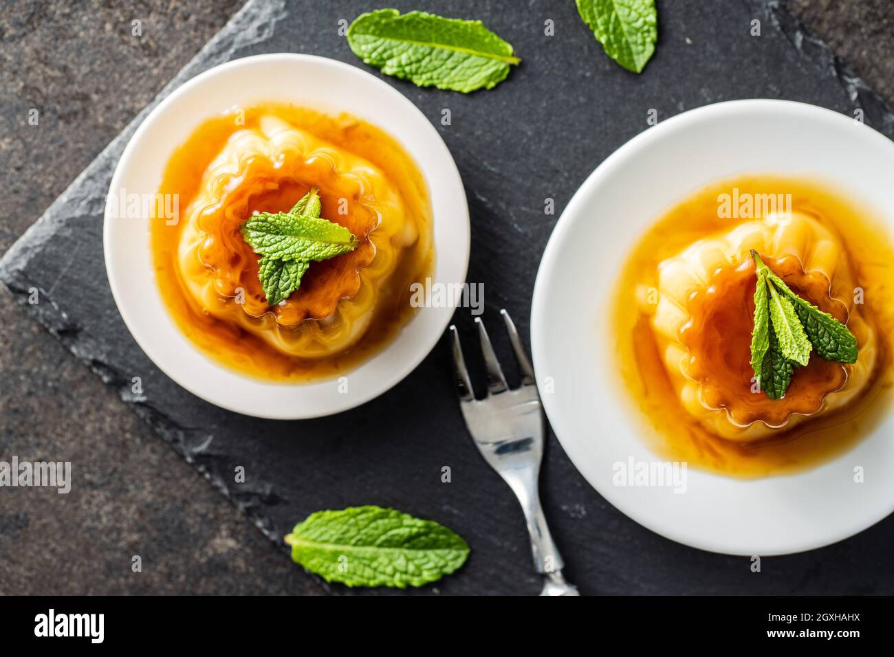 Sweet vanilla pudding. Sweet dessert with caramel topping on black ...