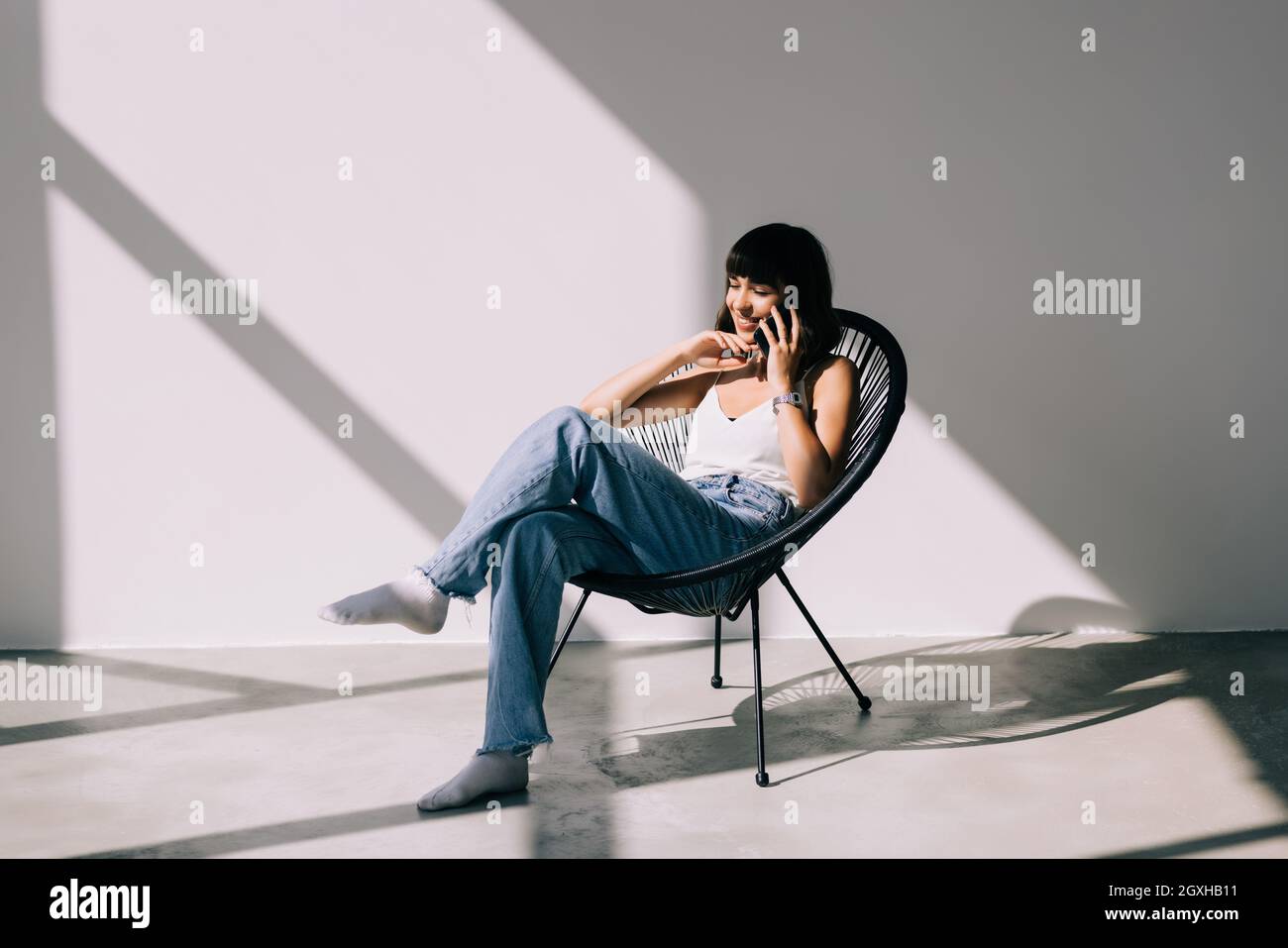 Beautiful young woman sitting on a chair and talking at phone Stock ...