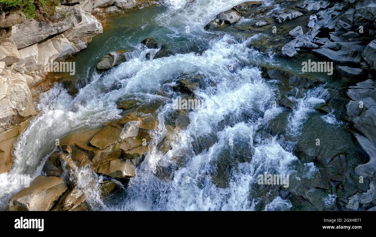 Powerful mountain stream breaking and flowing over sharp rocks and ...