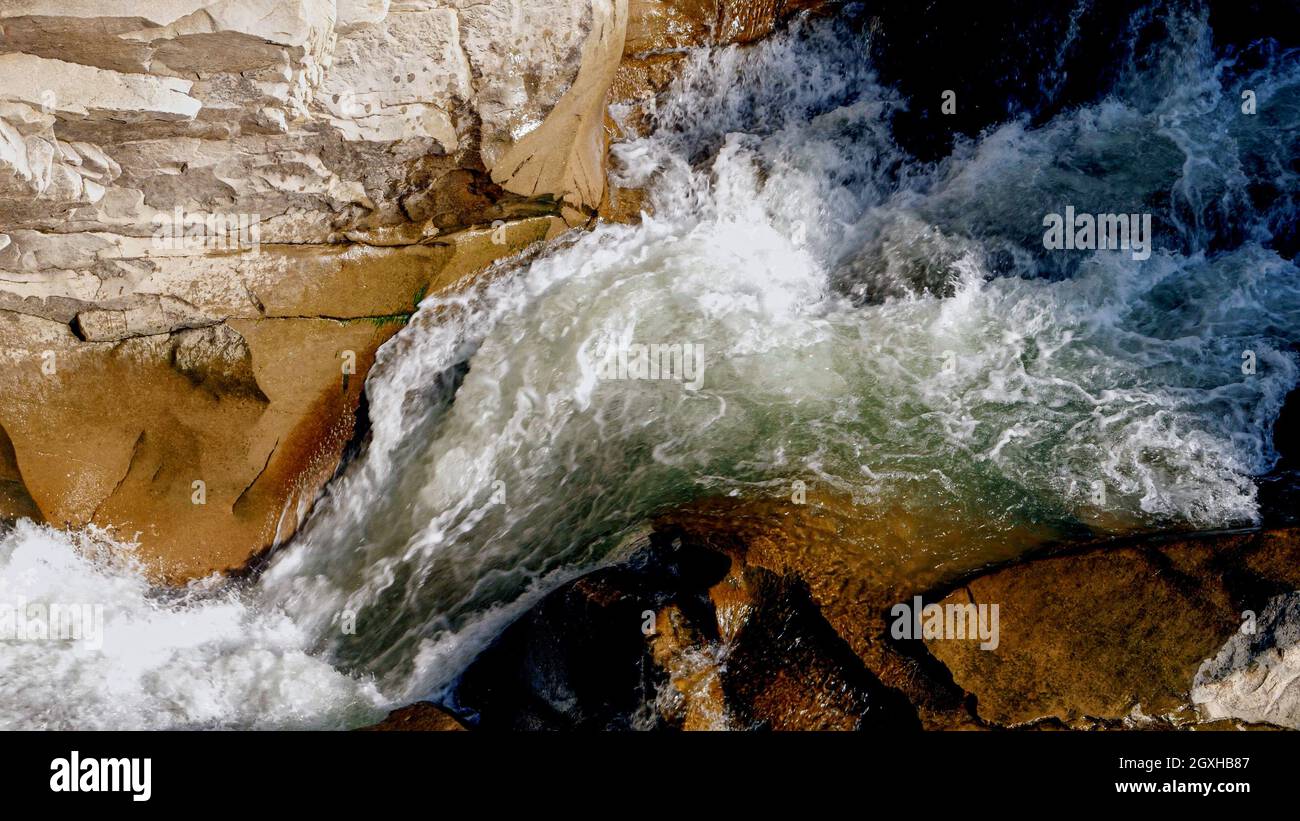 Fast and rapid water stream flowing over sharp rocks and cliffs Stock ...