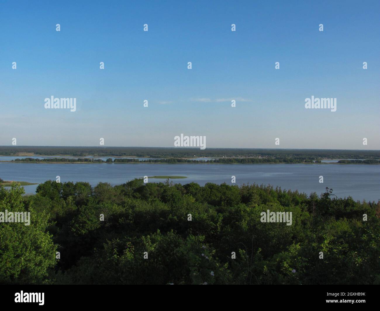 landscape background: green forest, river with islands and blue sky ...