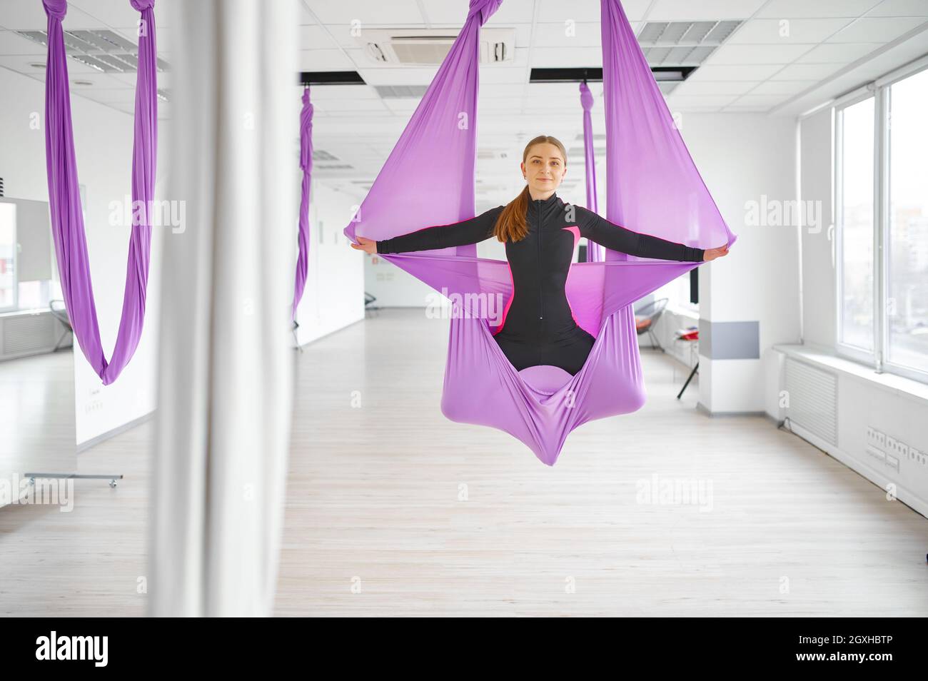 Aerial or antigravity yoga, group training, hanging on hammocks ...