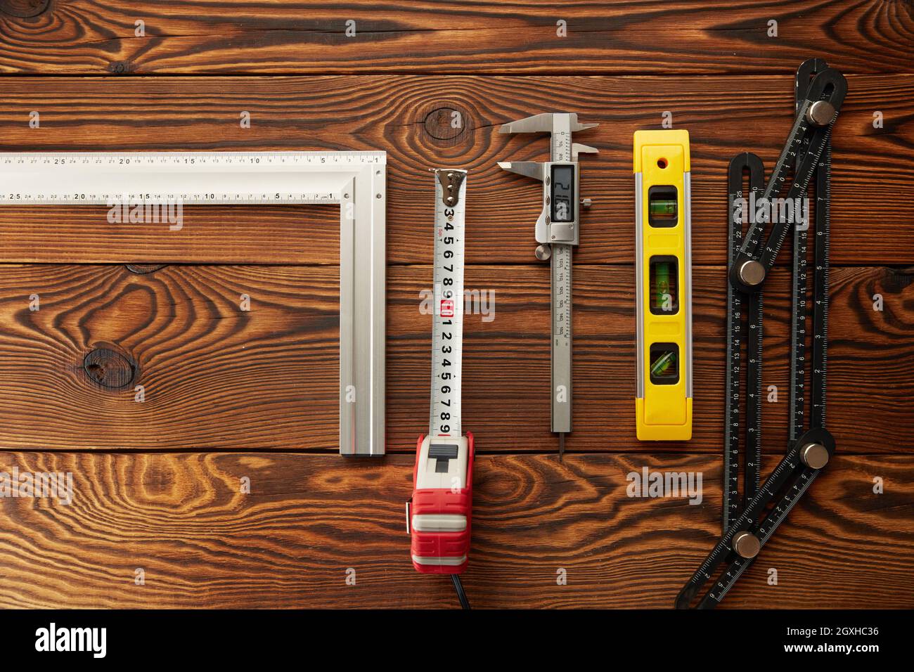 Level and corner, ruler and caliper, wooden background, top view ...