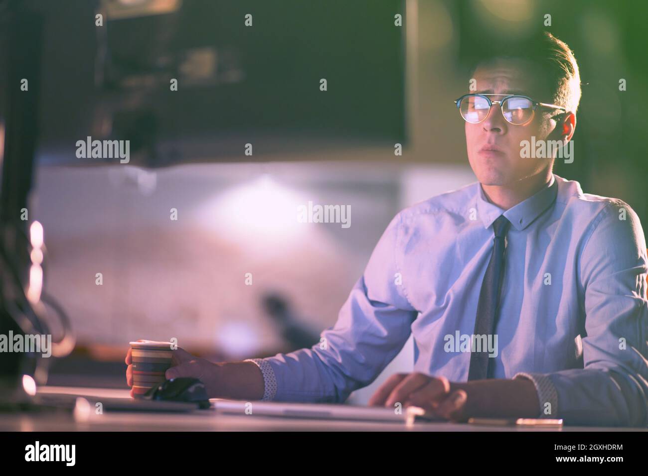 Tired businessman working late doing overtime in office at night ...