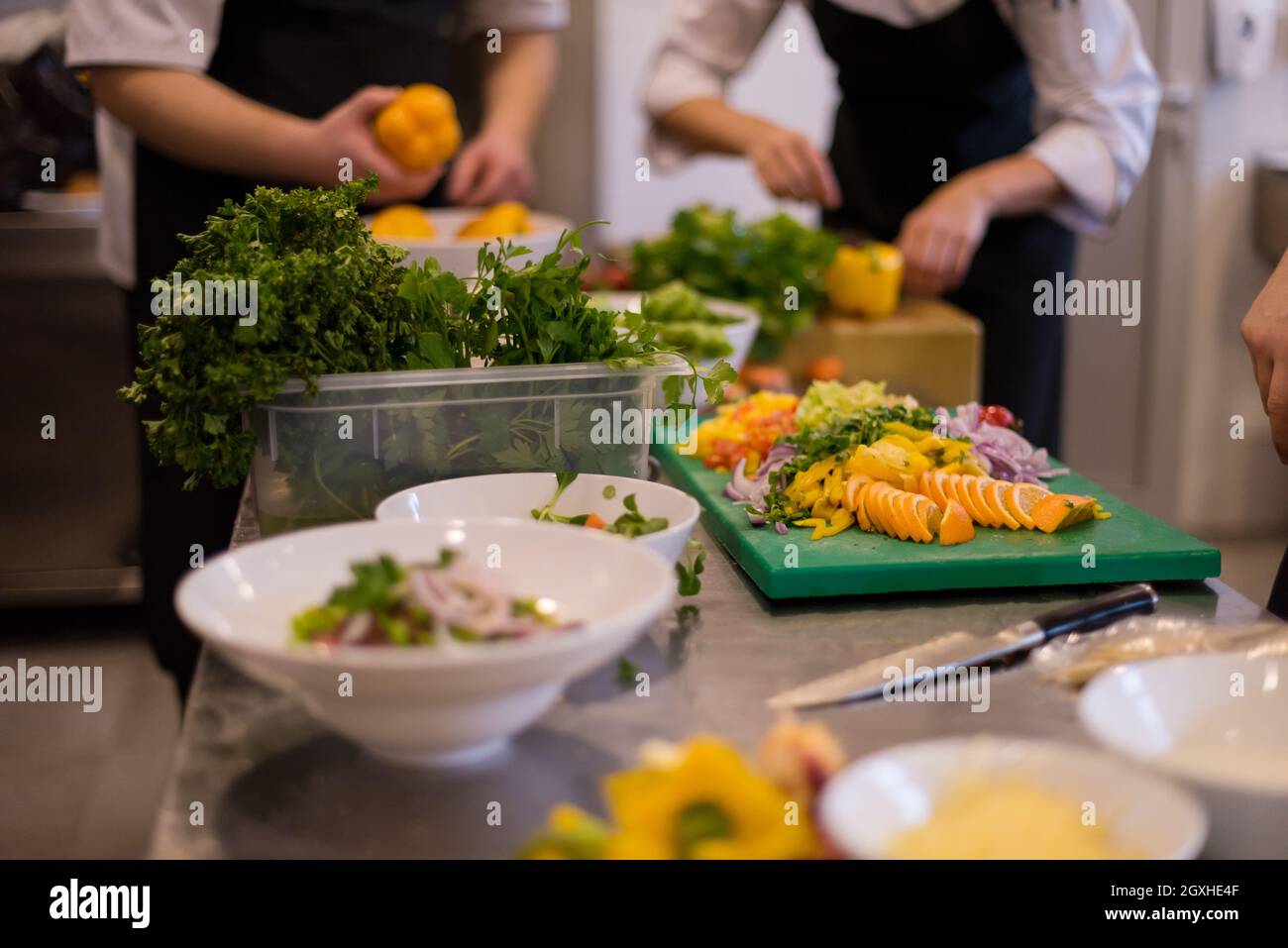 Professional team cooks and chefs preparing meal at busy hotel or ...