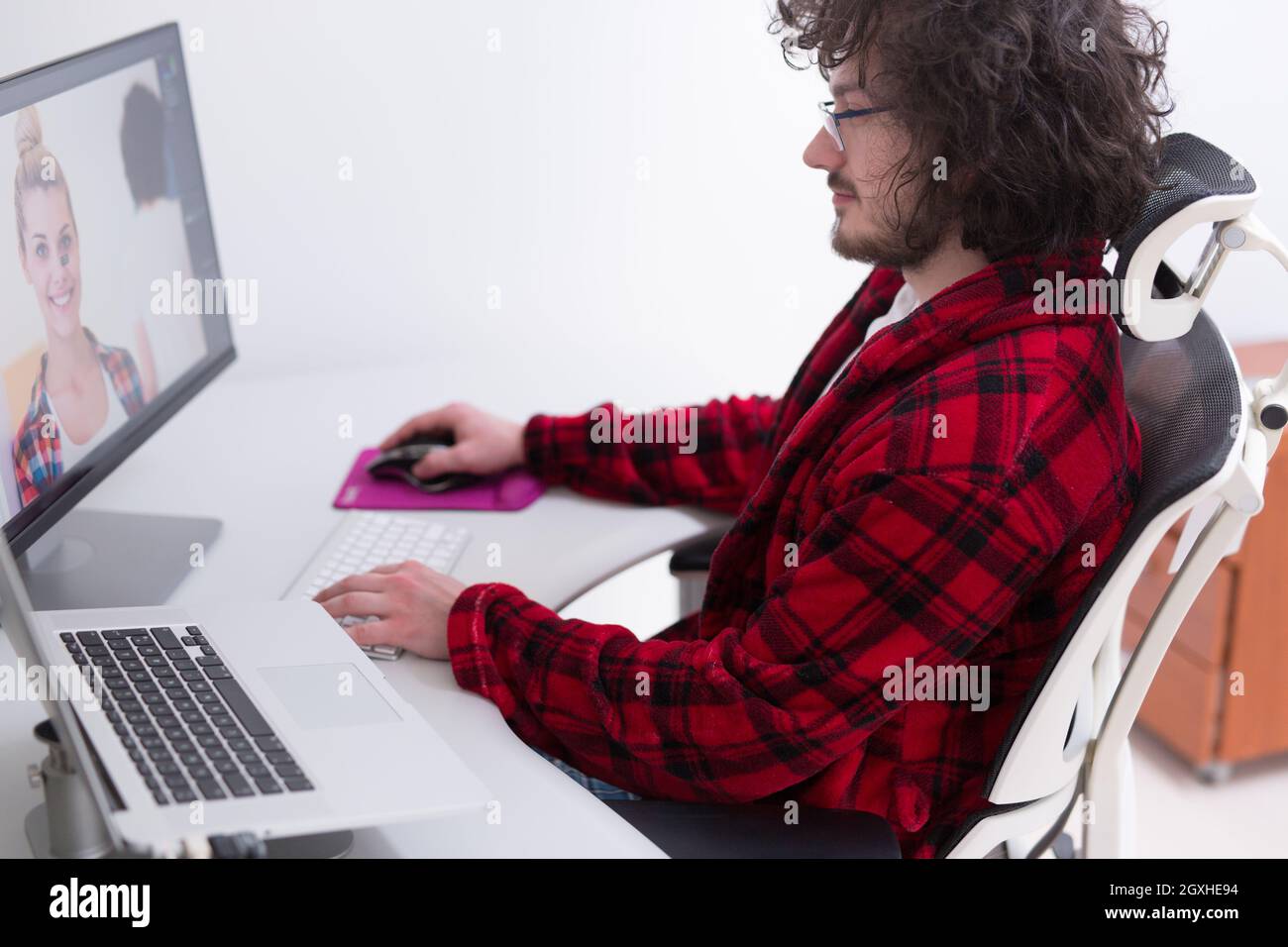 young graphic designer in bathrobe working at home office using ...