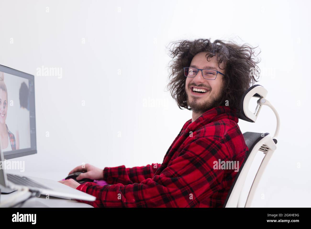 young graphic designer in bathrobe working at home office using ...