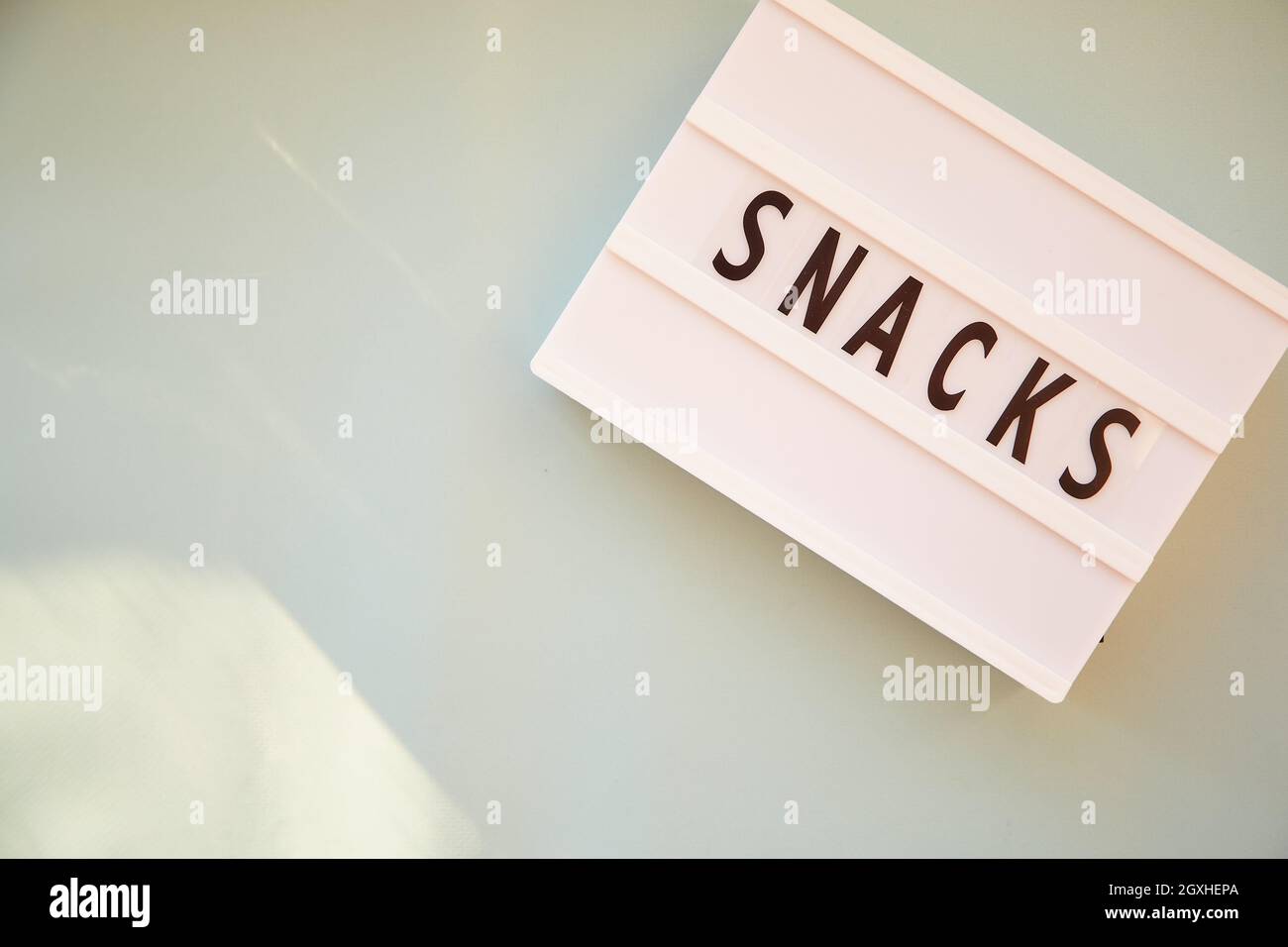 Text snacks with copy space and trendy shadows. Top view. Proper ...