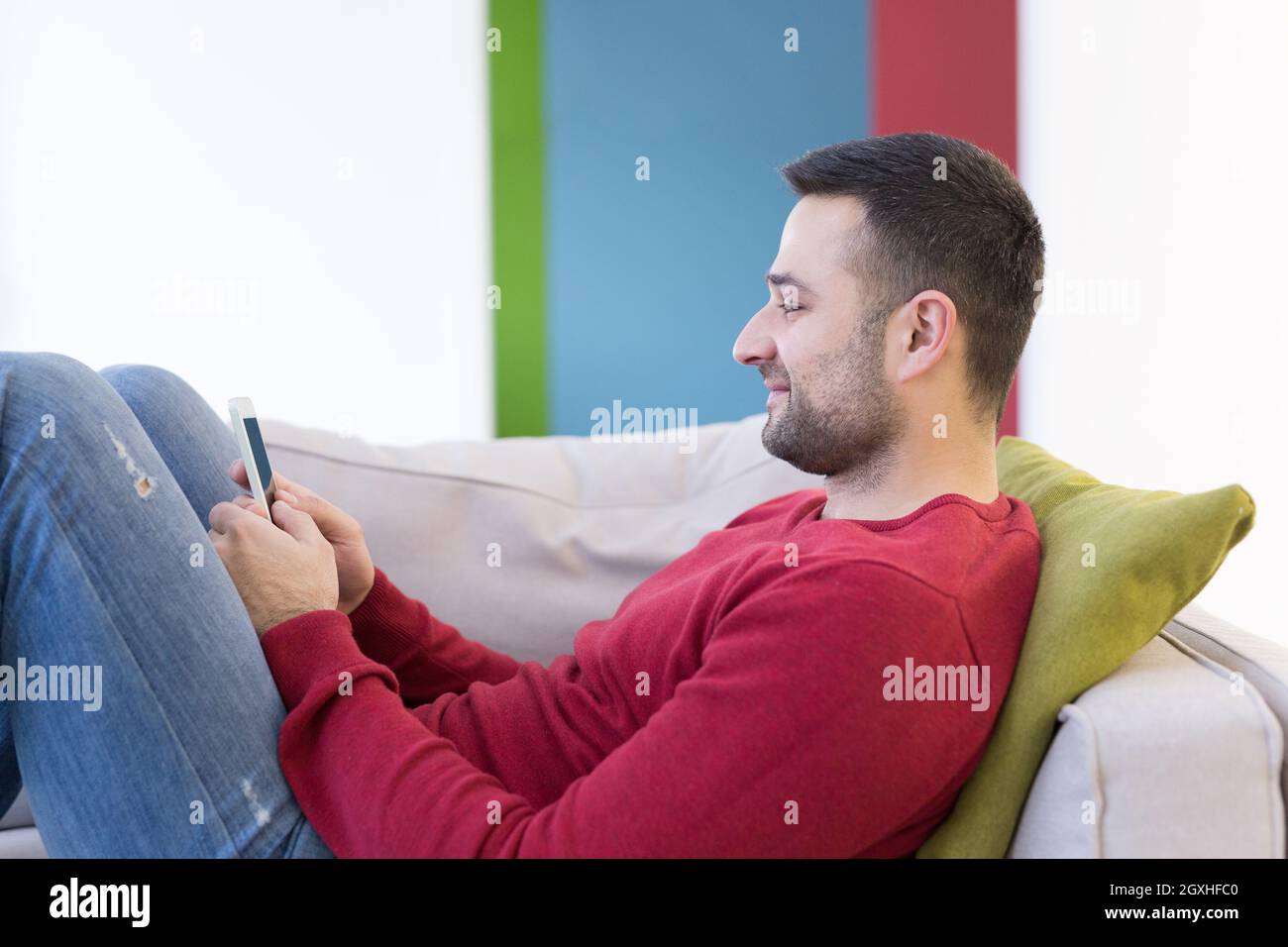 Handsome casual young man using a mobile phone at home Stock Photo - Alamy