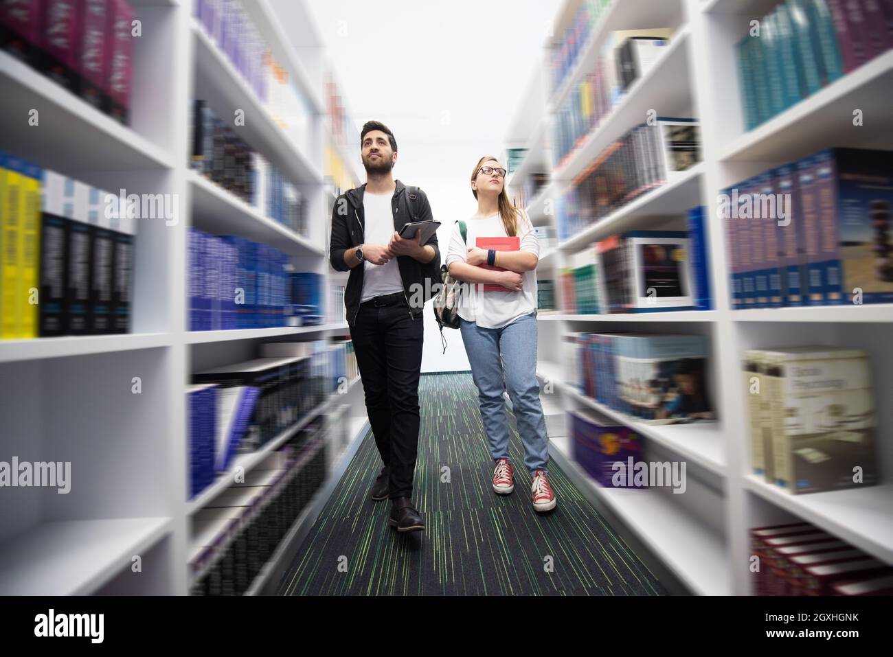 happy students group in school library selecting books to read and ...