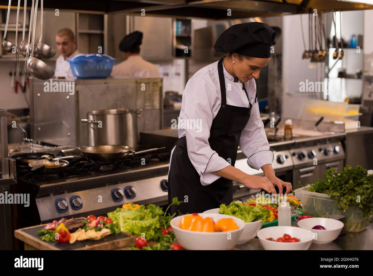 chef serving vegetable salad on plate in restaurant kitchen Stock Photo ...