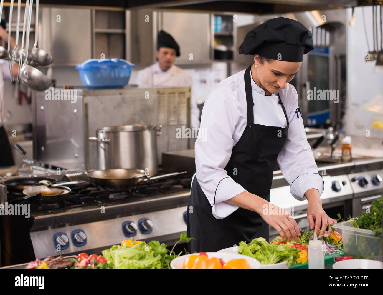 chef serving vegetable salad on plate in restaurant kitchen Stock Photo ...