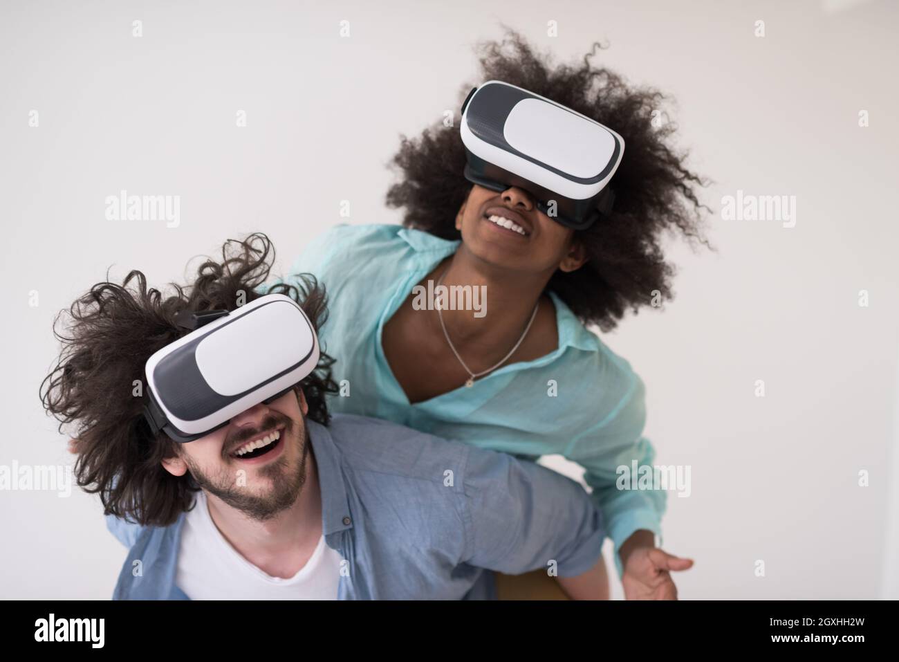 Happy multiethnic couple getting experience using VR headset glasses of ...