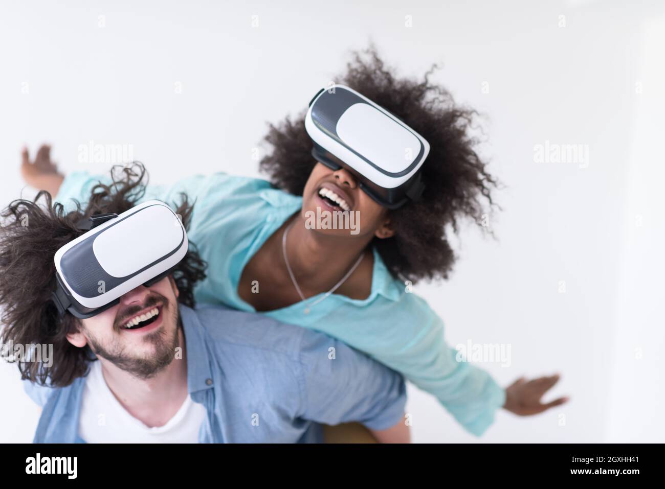 Happy multiethnic couple getting experience using VR headset glasses of ...