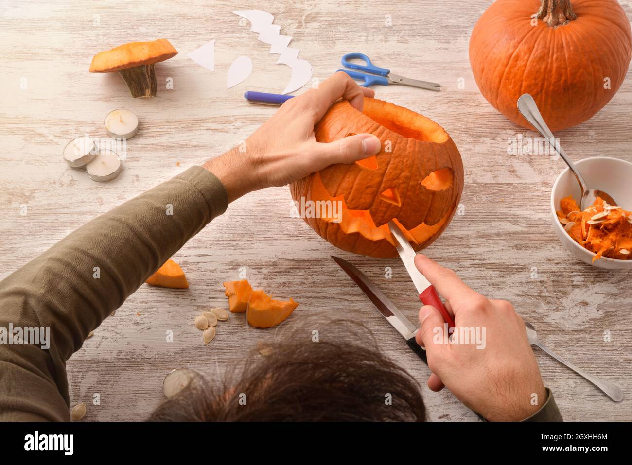 Detail of man carving and emptying a pumpkin for the halloween party ...