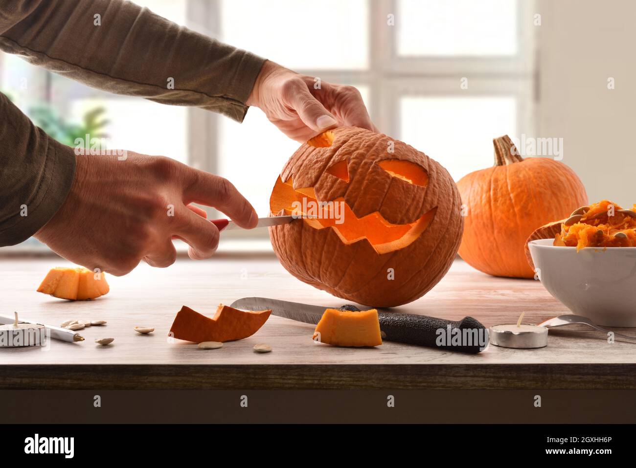 Detail of man carving and emptying a pumpkin for the halloween party at ...
